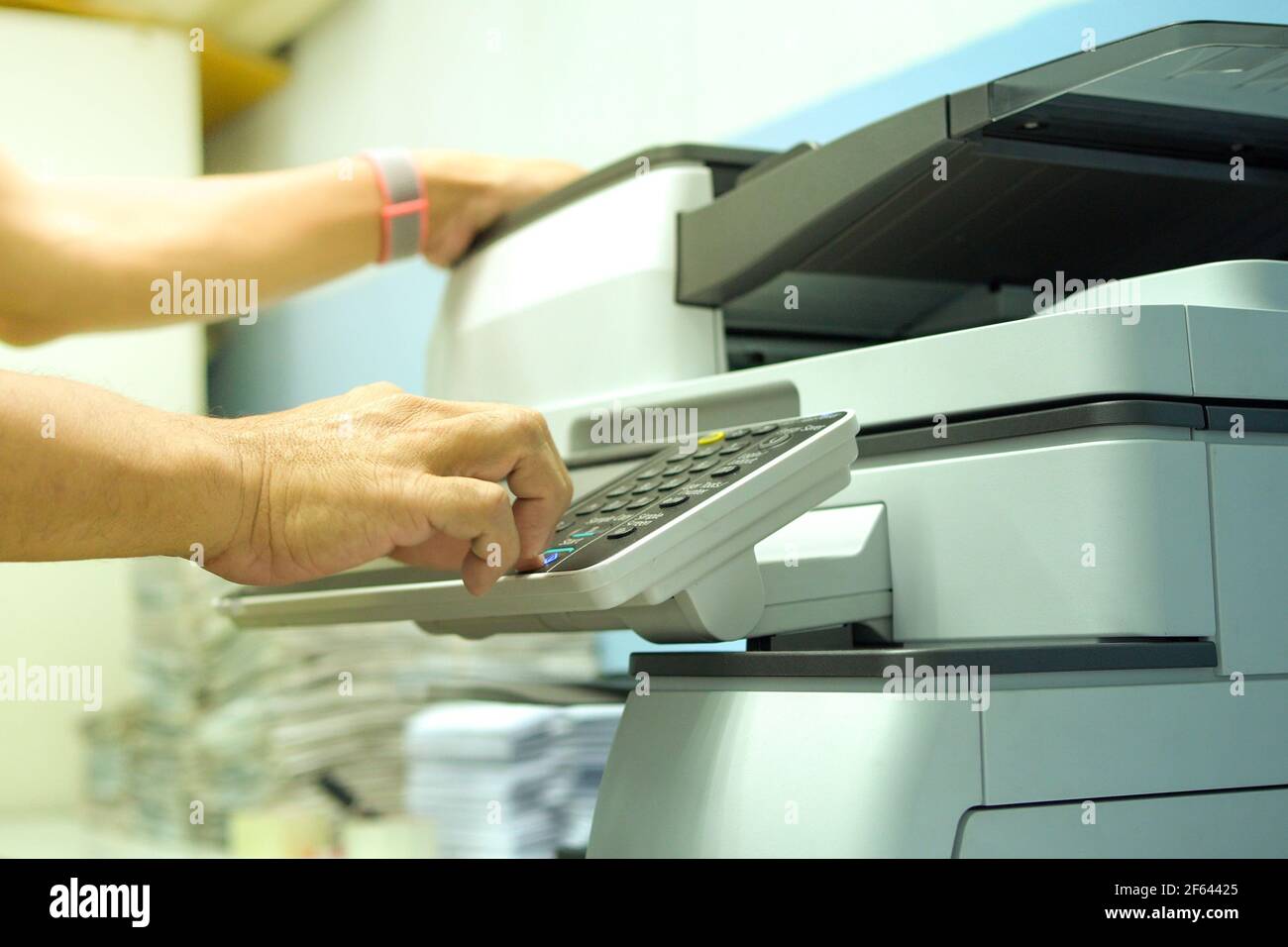 Hand of man is pressing the start button to using a photocopier to copy ...
