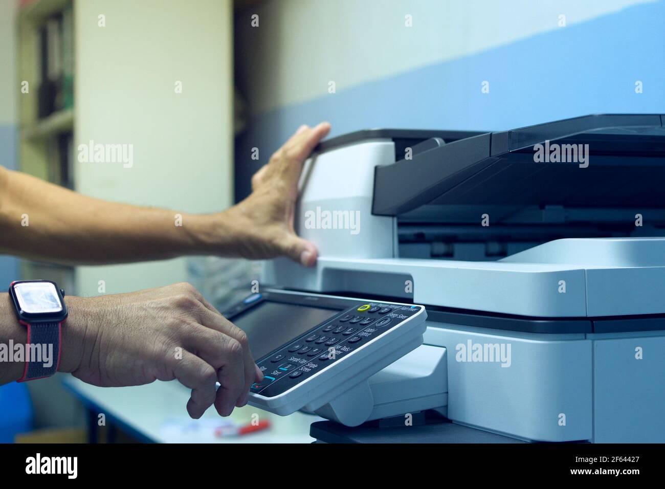 Hand of man is pressing the start button to using a photocopier to copy ...