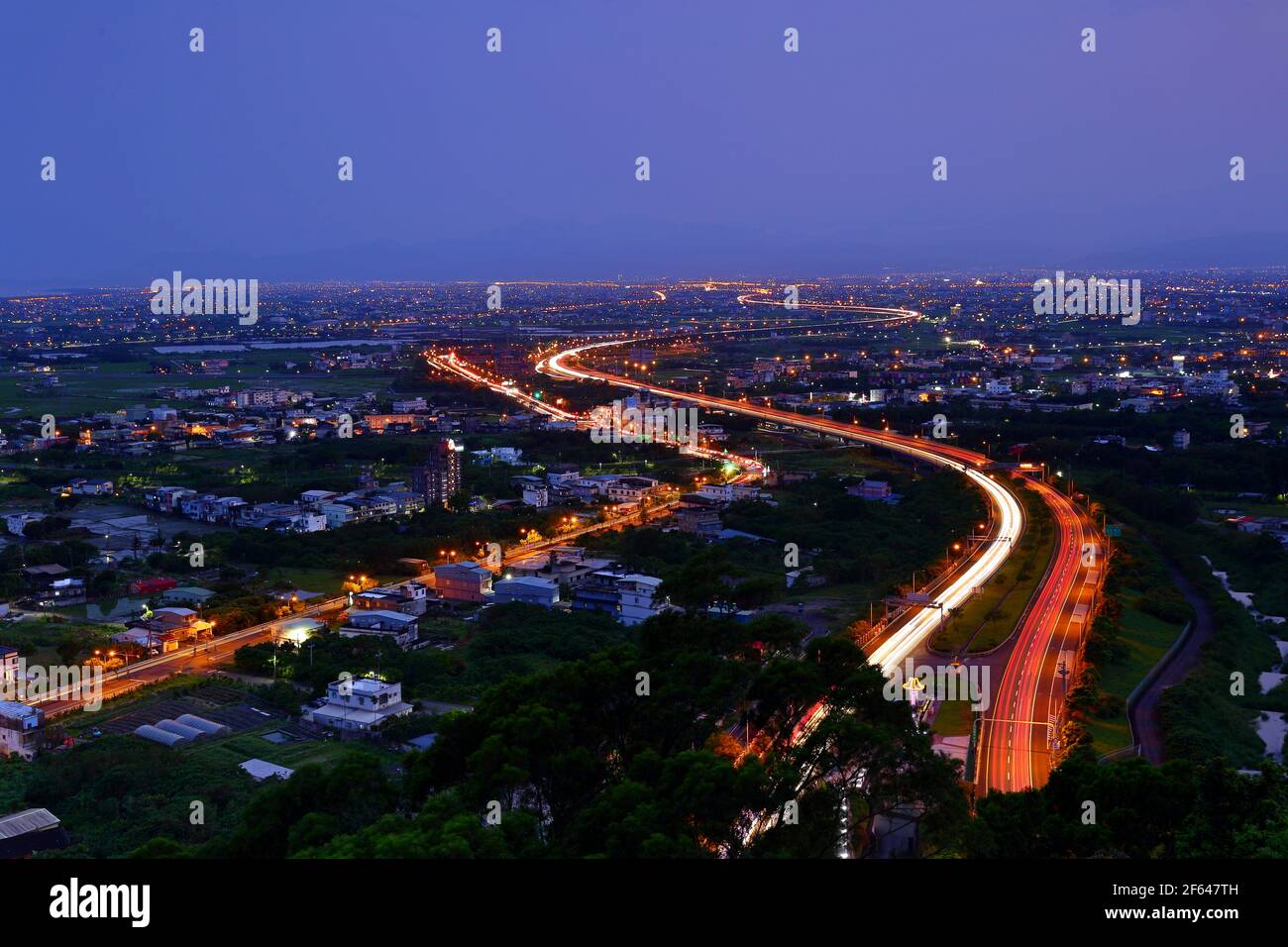 Night aerial view of the Lanyang Plain, with car light trails at night ...