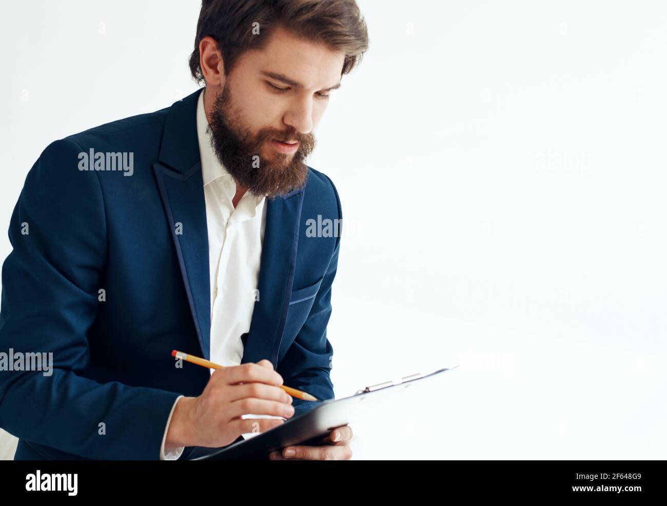 Business man in a suit with documents writes down important information ...