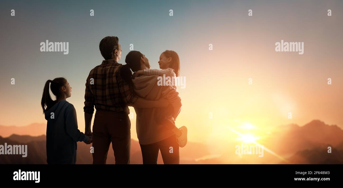 Happy family at sunset. Father, mother and children are having fun and ...