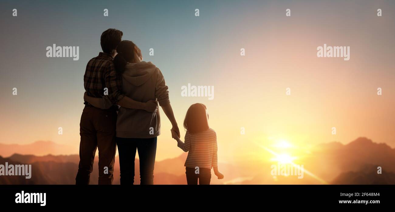 Happy family at sunset. Father, mother and child are having fun and ...