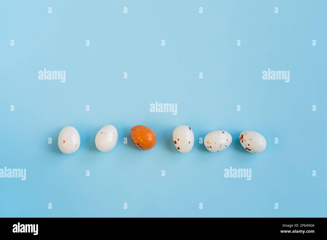 Easter minimal composition with multicolored eggs on the blue ...