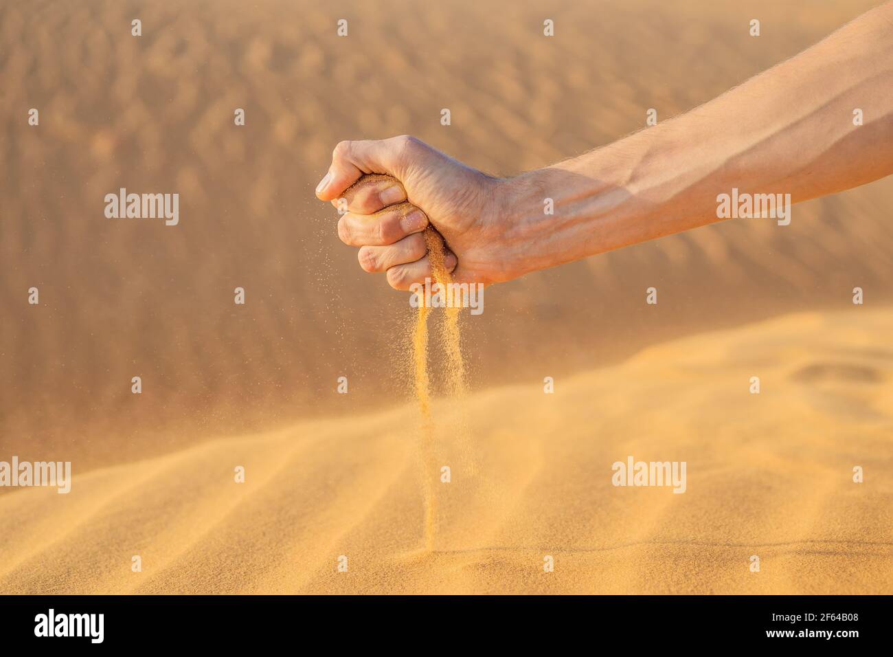 Desert, sand puffs through the fingers of a mans hand Stock Photo - Alamy