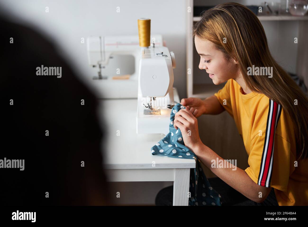 Charming girl seamstress sewing clothes in workshop Stock Photo - Alamy