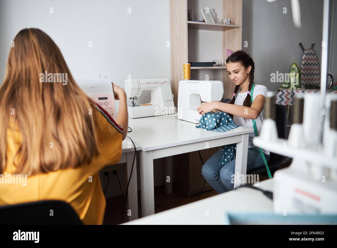 Cute girls sewing clothes in dressmaking studio Stock Photo - Alamy