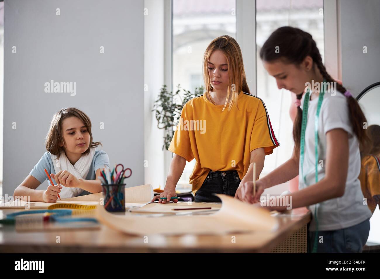Cute female children drafting sewing patterns in workshop Stock Photo ...