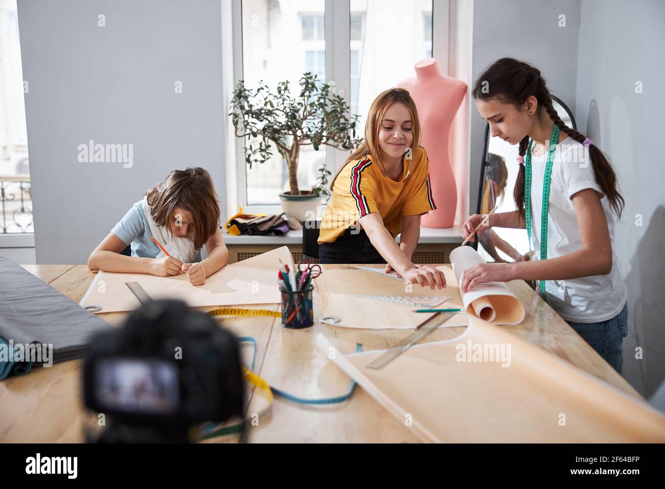 Cute female children making sewing patterns in workshop Stock Photo - Alamy