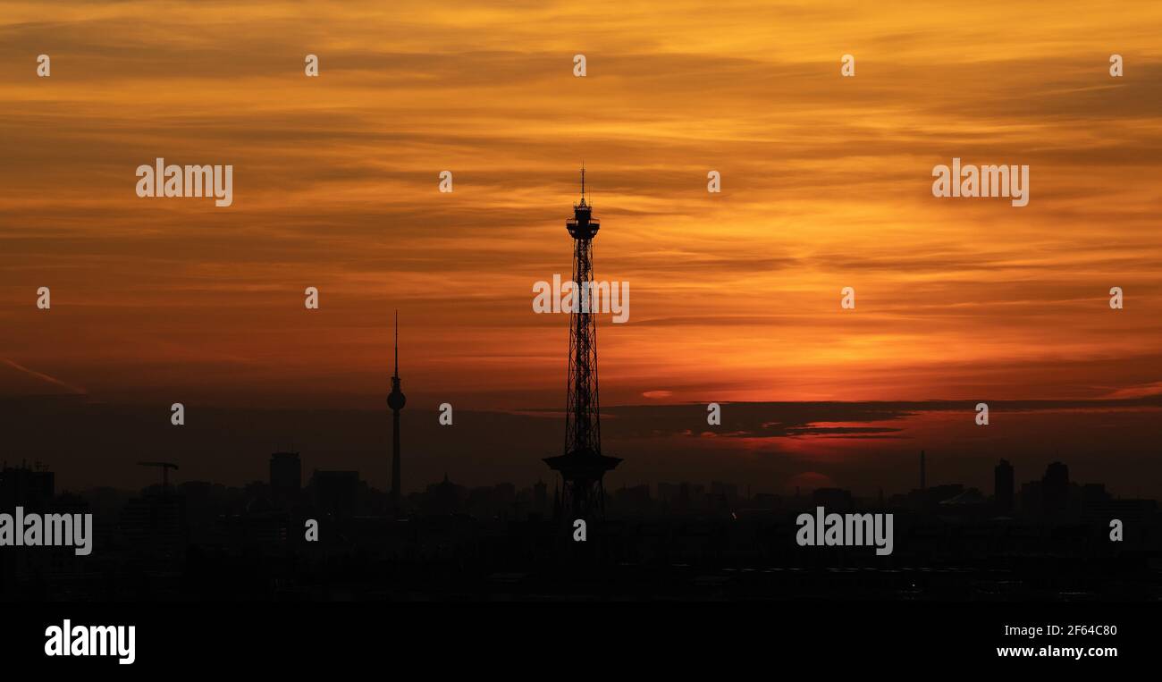 Berlin, Germany. 30th Mar, 2021. The rising sun colours the sky above ...