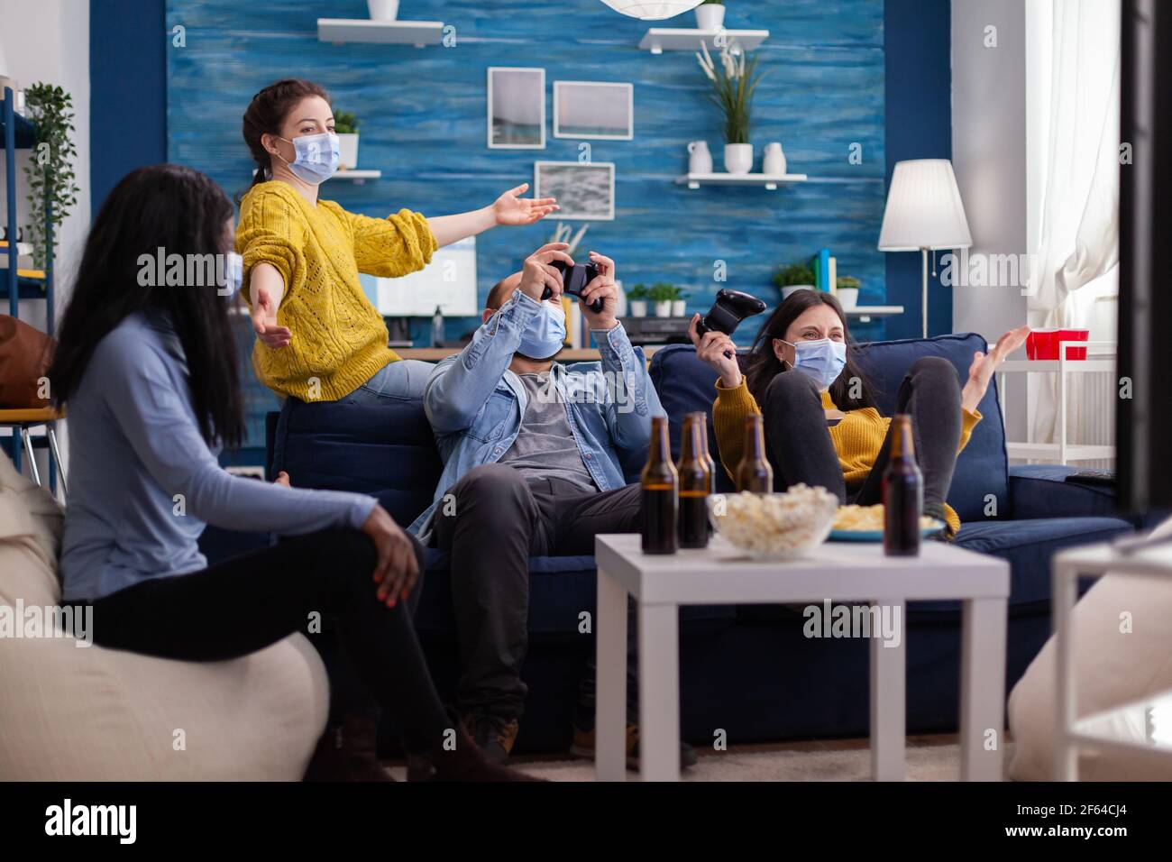 Multiethnic friends celebrating victory playing video games in living ...