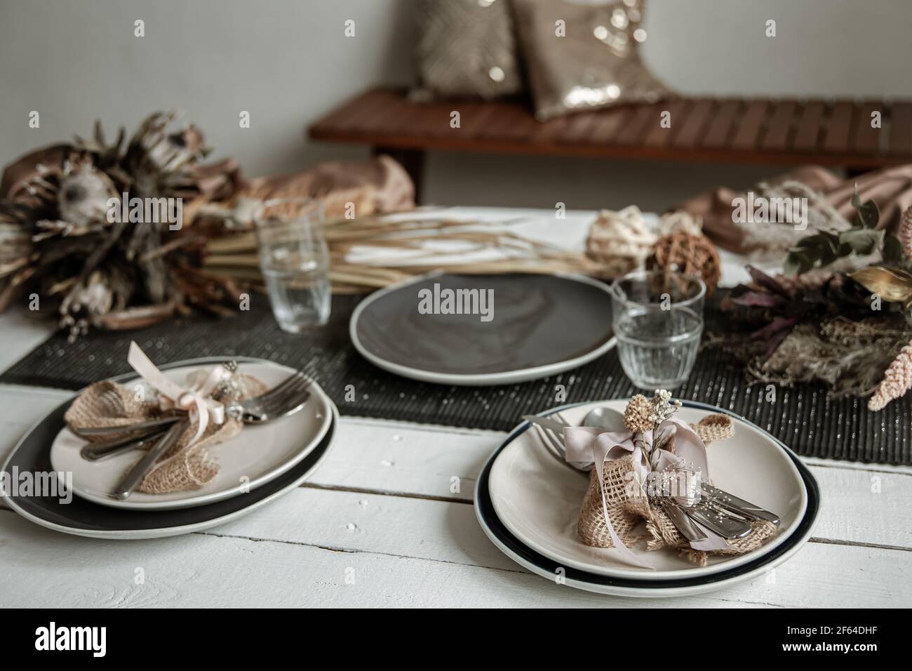 Stylish crockery and cutlery on a set table in coffee colors with ...