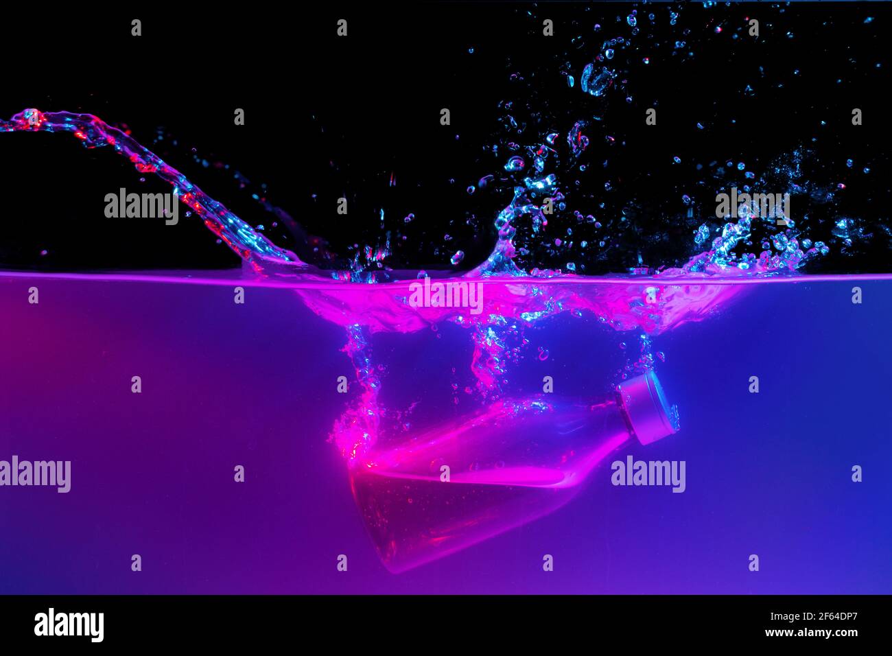 Skincare product bottle falling into water against black background in ...