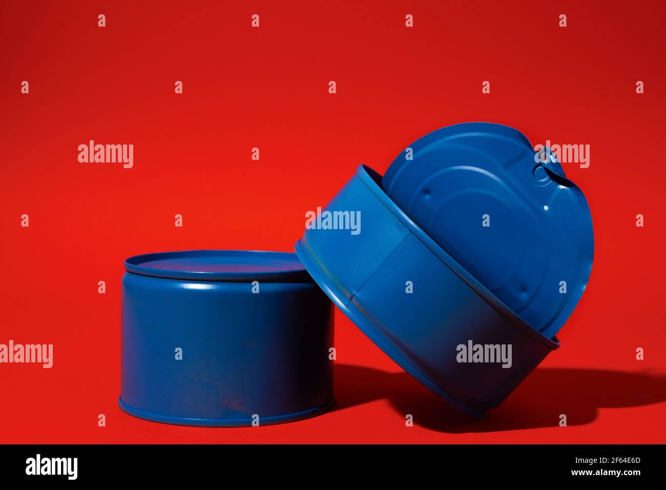 Blue tin can on dark red background Stock Photo - Alamy