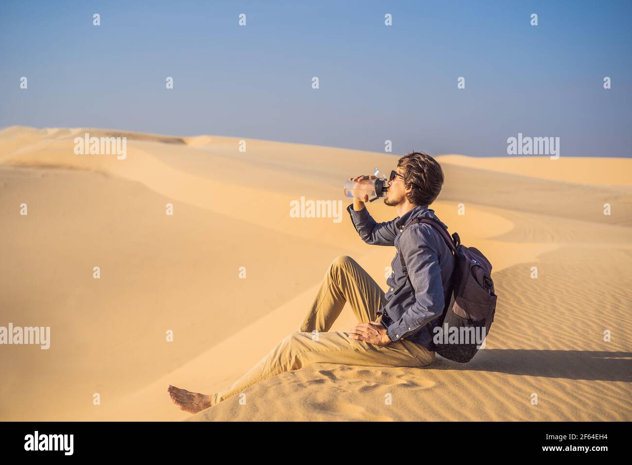 Man feels thirst and drinks water in the desert Stock Photo - Alamy