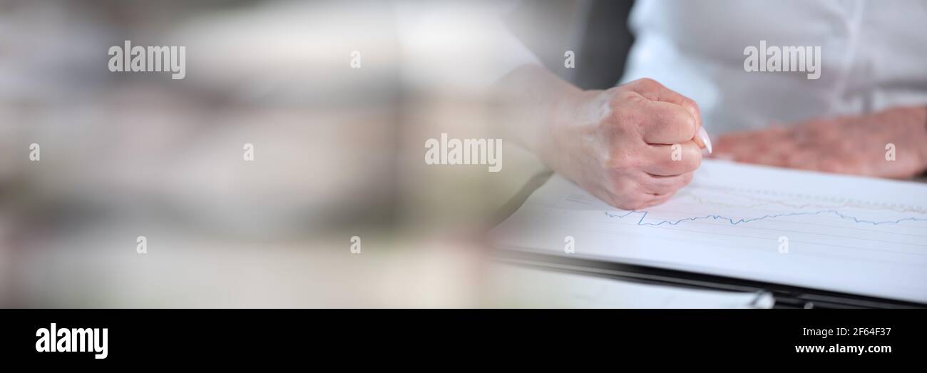 Angry businesswoman hitting her desk with her clenched fist; panoramic ...