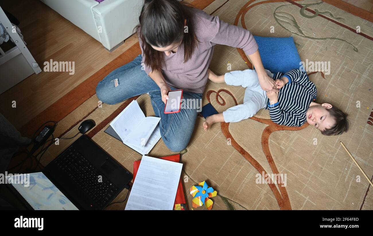 The child interferes with the mother's work at the computer. High ...