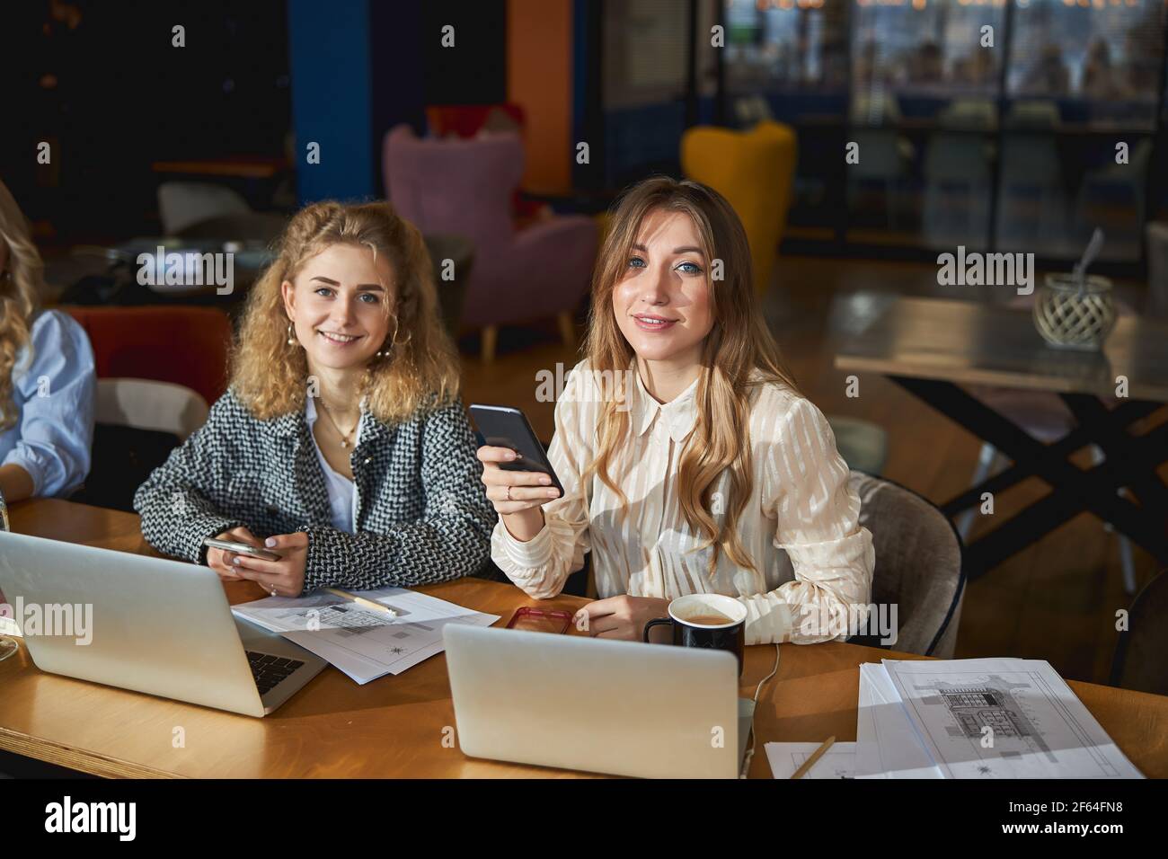 Charming women using laptops and smartphones at work Stock Photo - Alamy