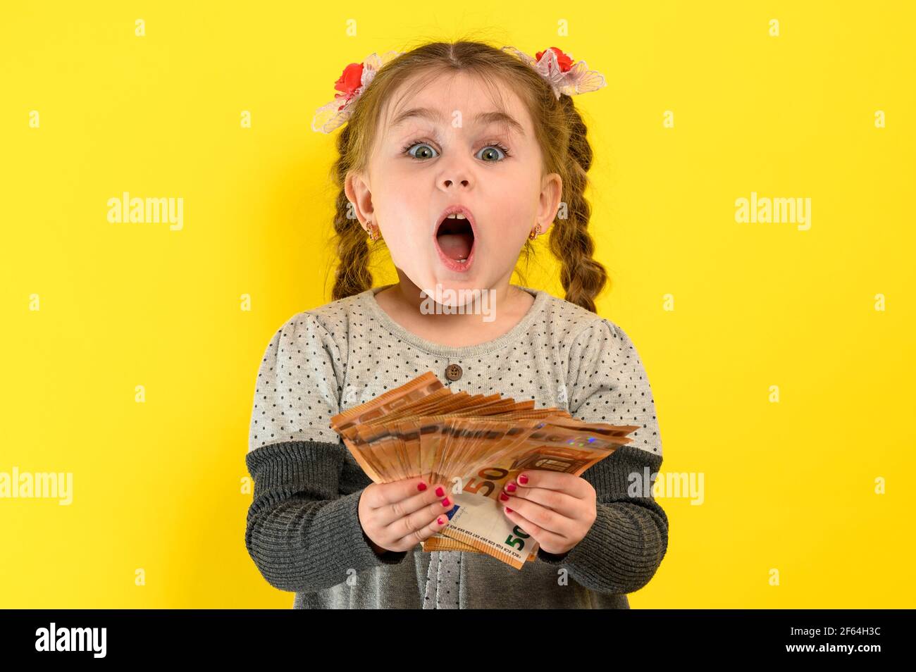 The girl is holding euro bills in denominations of 50 euros, a child ...