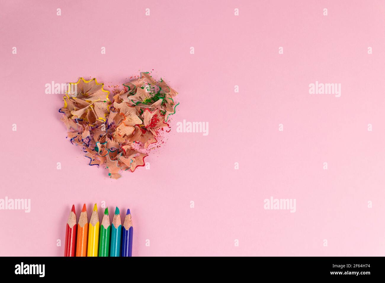 sharpened colored pencils and heart-shaped pencil shavings on pastel ...