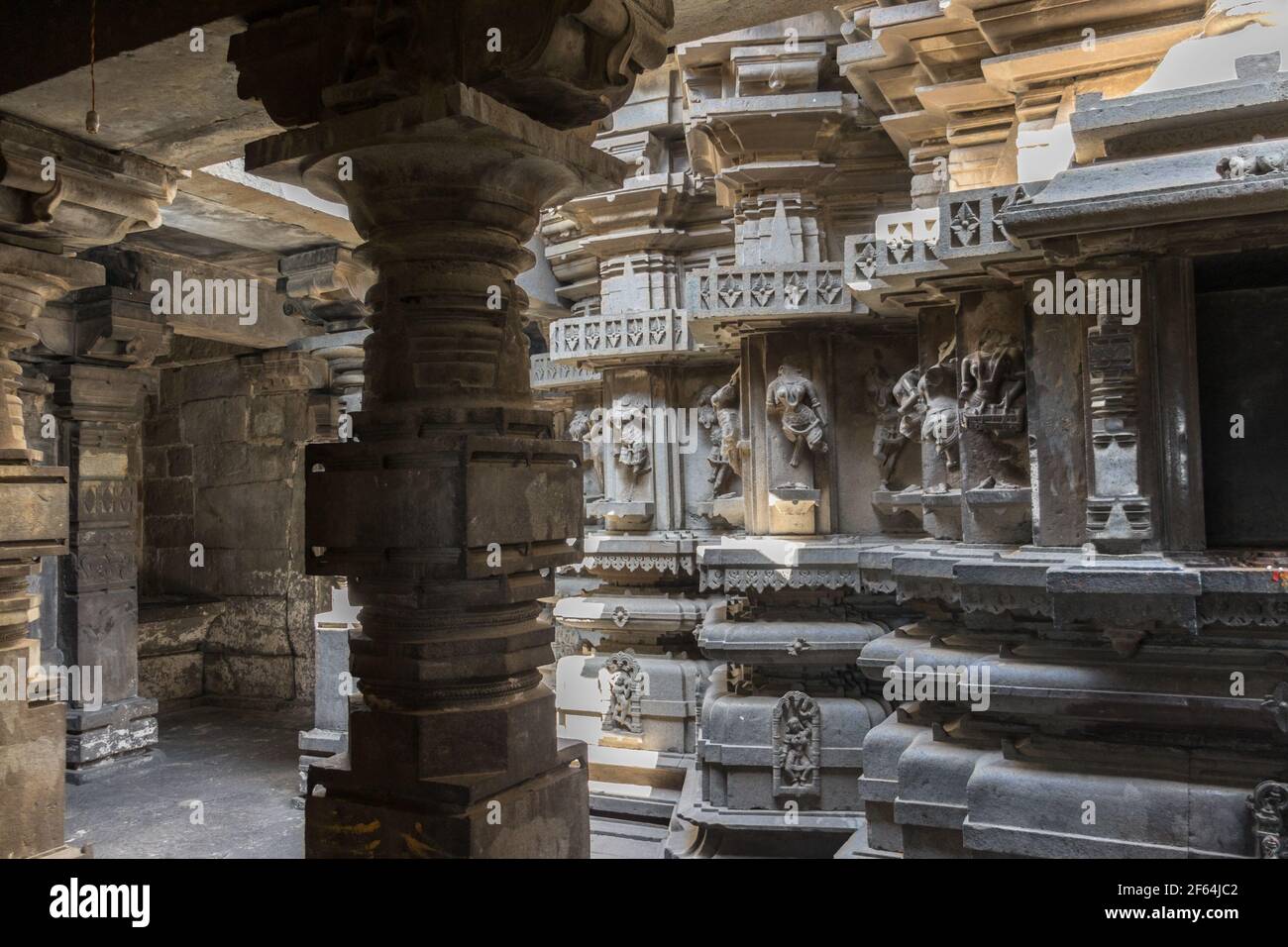 view of old hindu temple with carved column and stone carved walls ...
