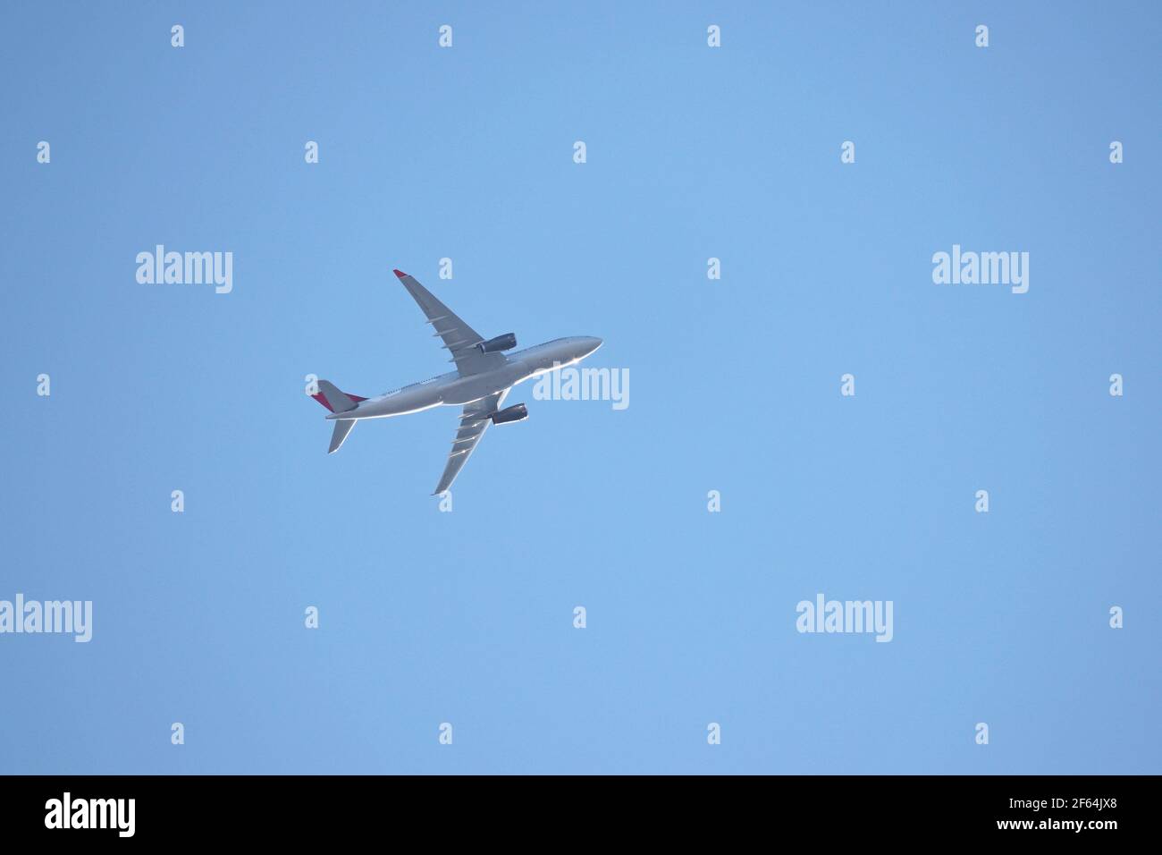 Airplane flying in the clear blue sky, bottom and side view. Commercial ...
