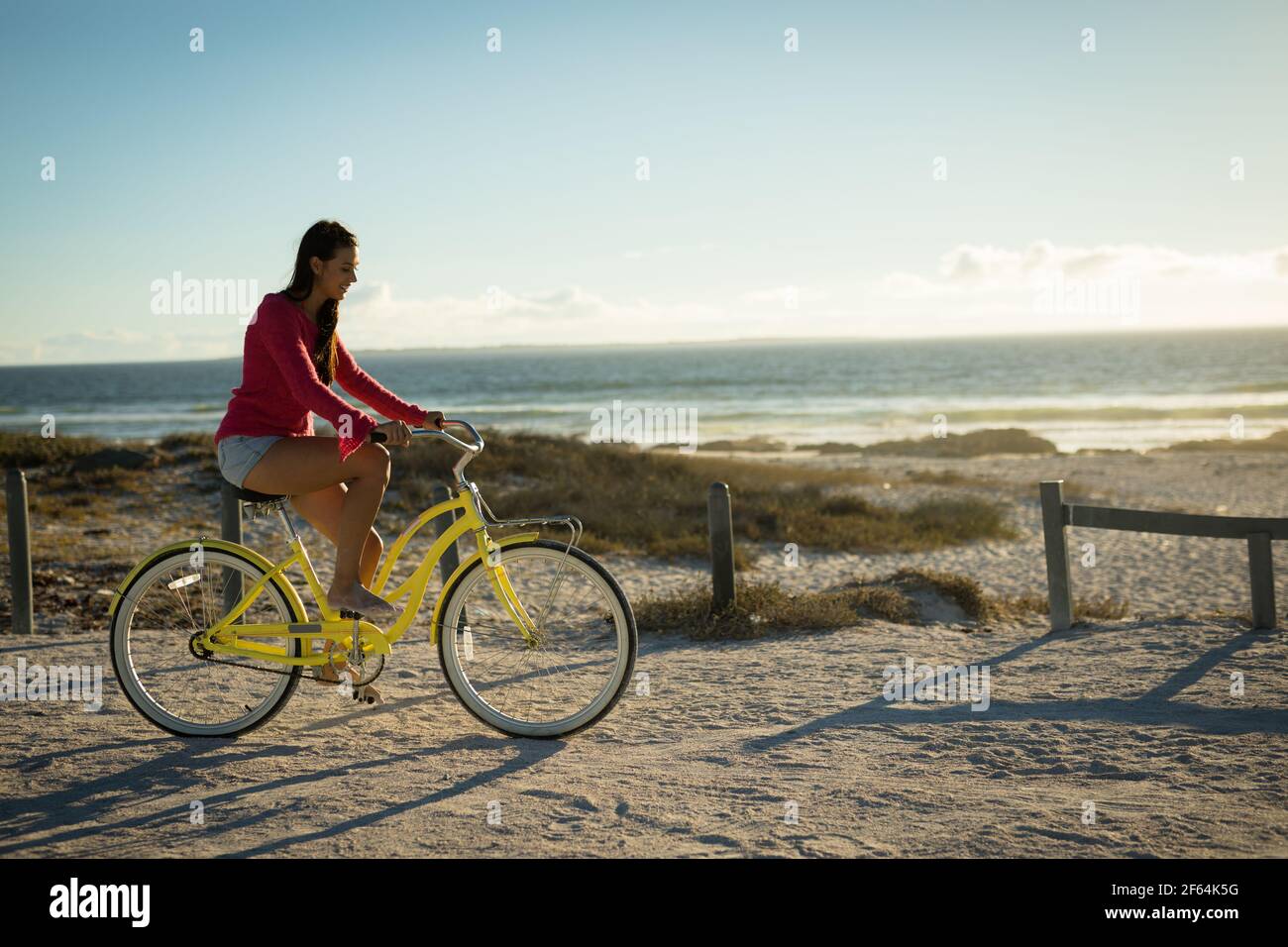 Happy caucasian woman on the beach riding bicycle Stock Photo - Alamy