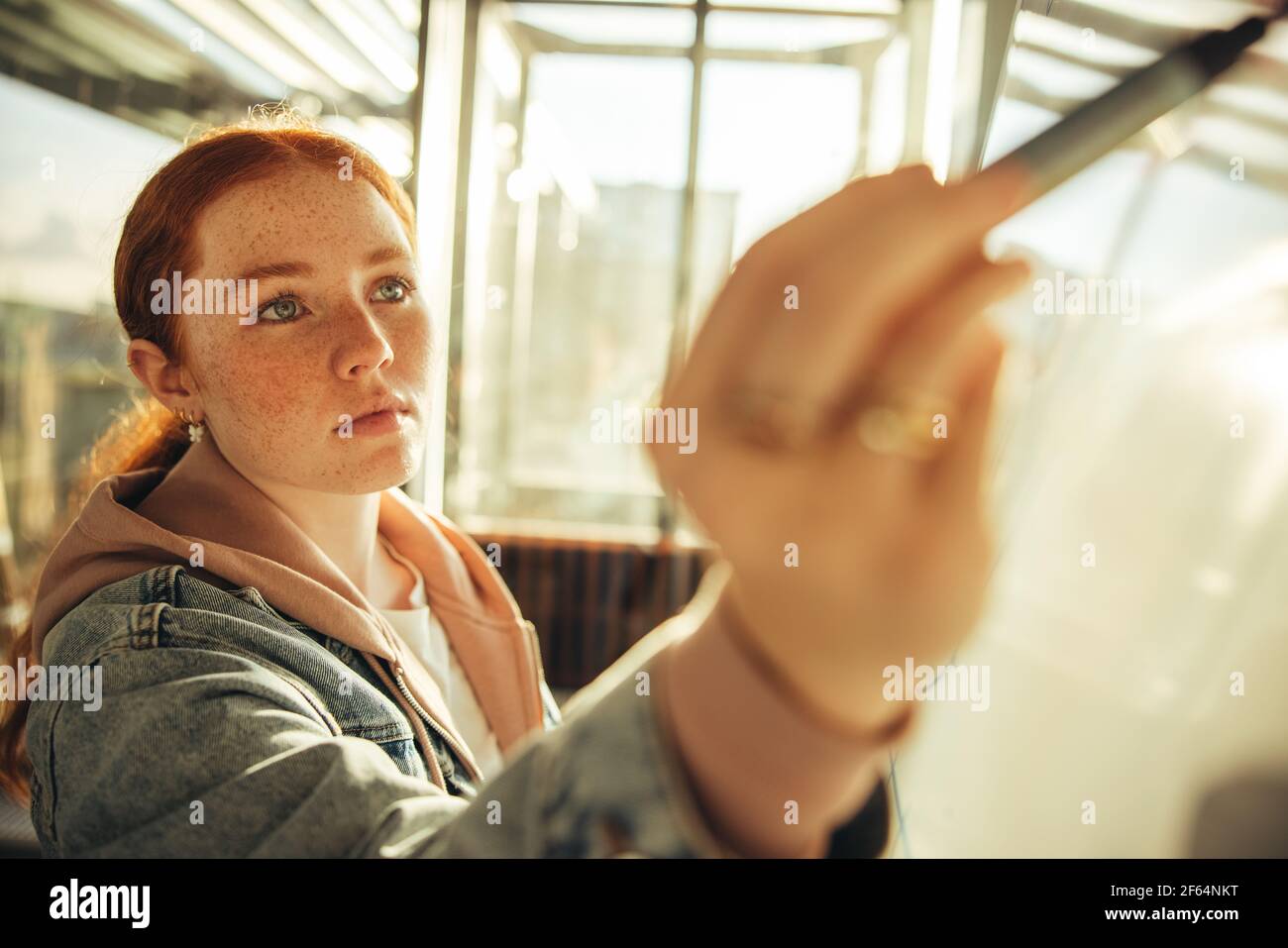 Girl student writing on whiteboard in college. Young female studying on ...