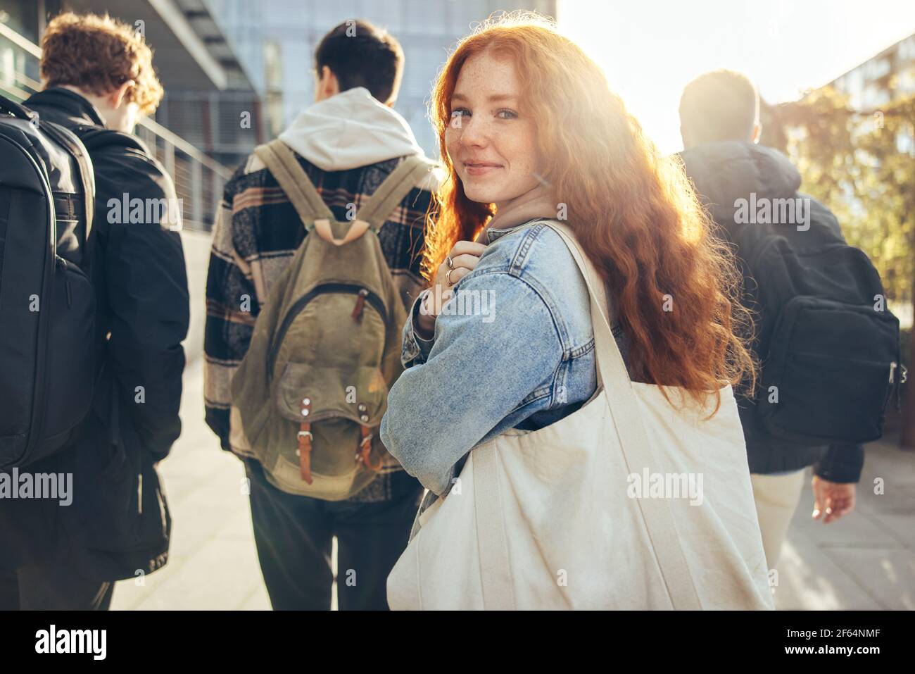 Female student glancing back while going for a class in college. Girl ...