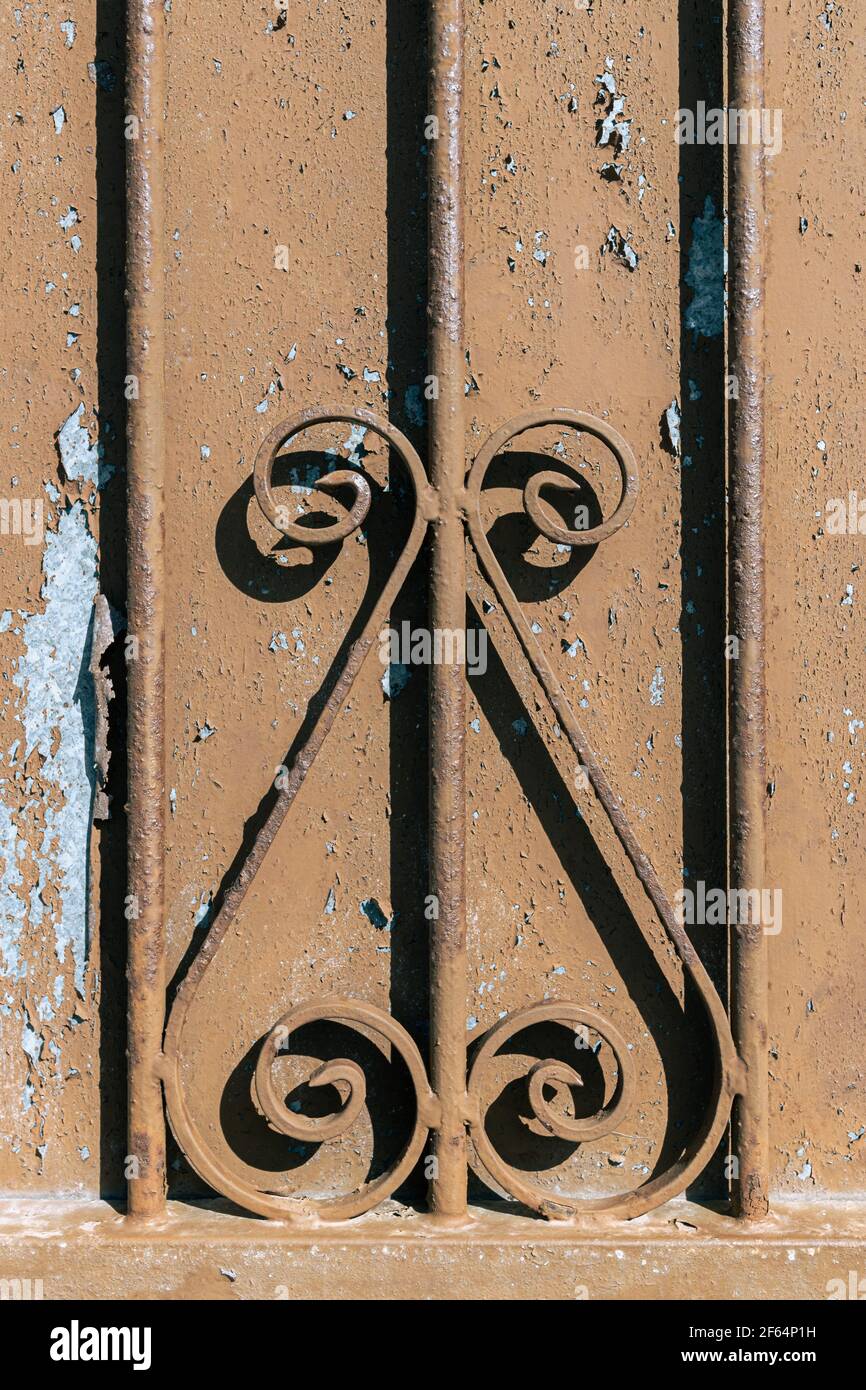Decorative loops on a metal gate with peeling paint Stock Photo - Alamy