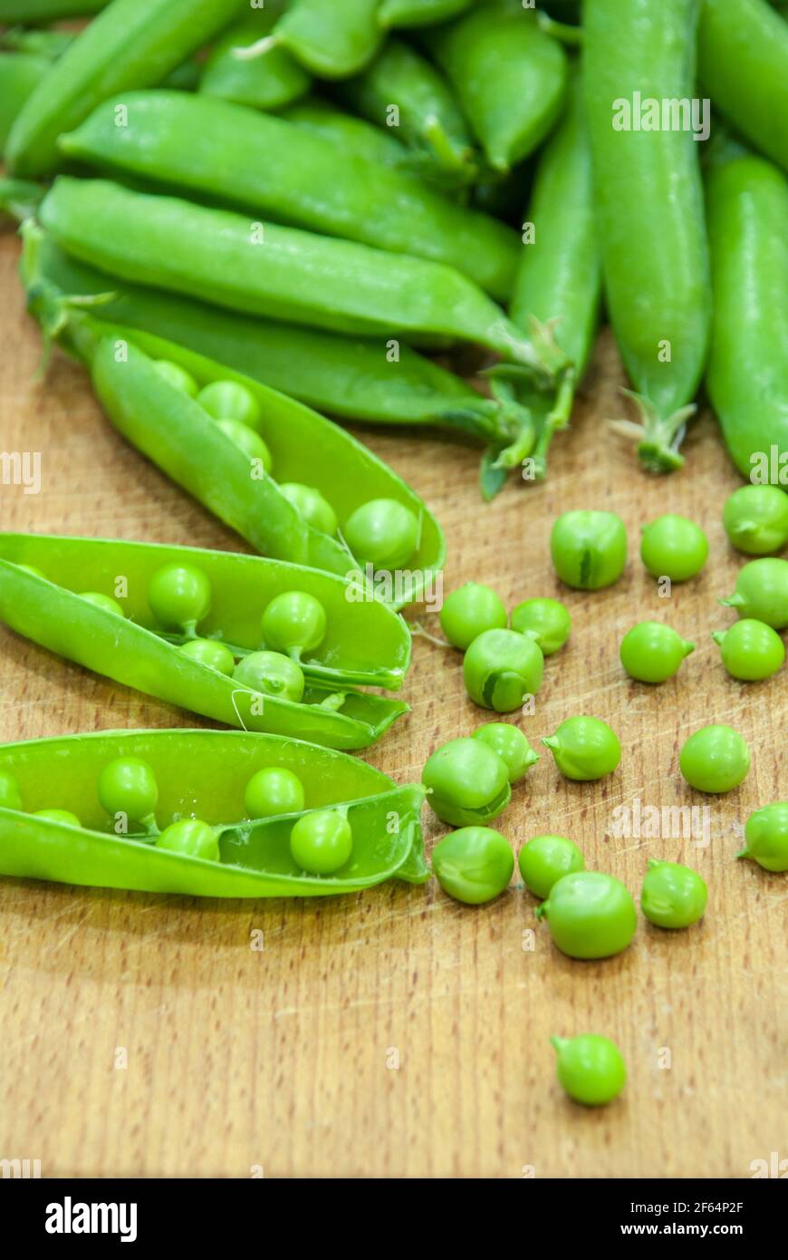 Fresh pods of sweet green peas in basket, on wooden board Stock Photo ...