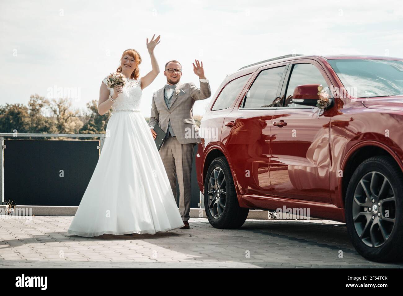 Bridal couple waving on their wedding day Stock Photo - Alamy