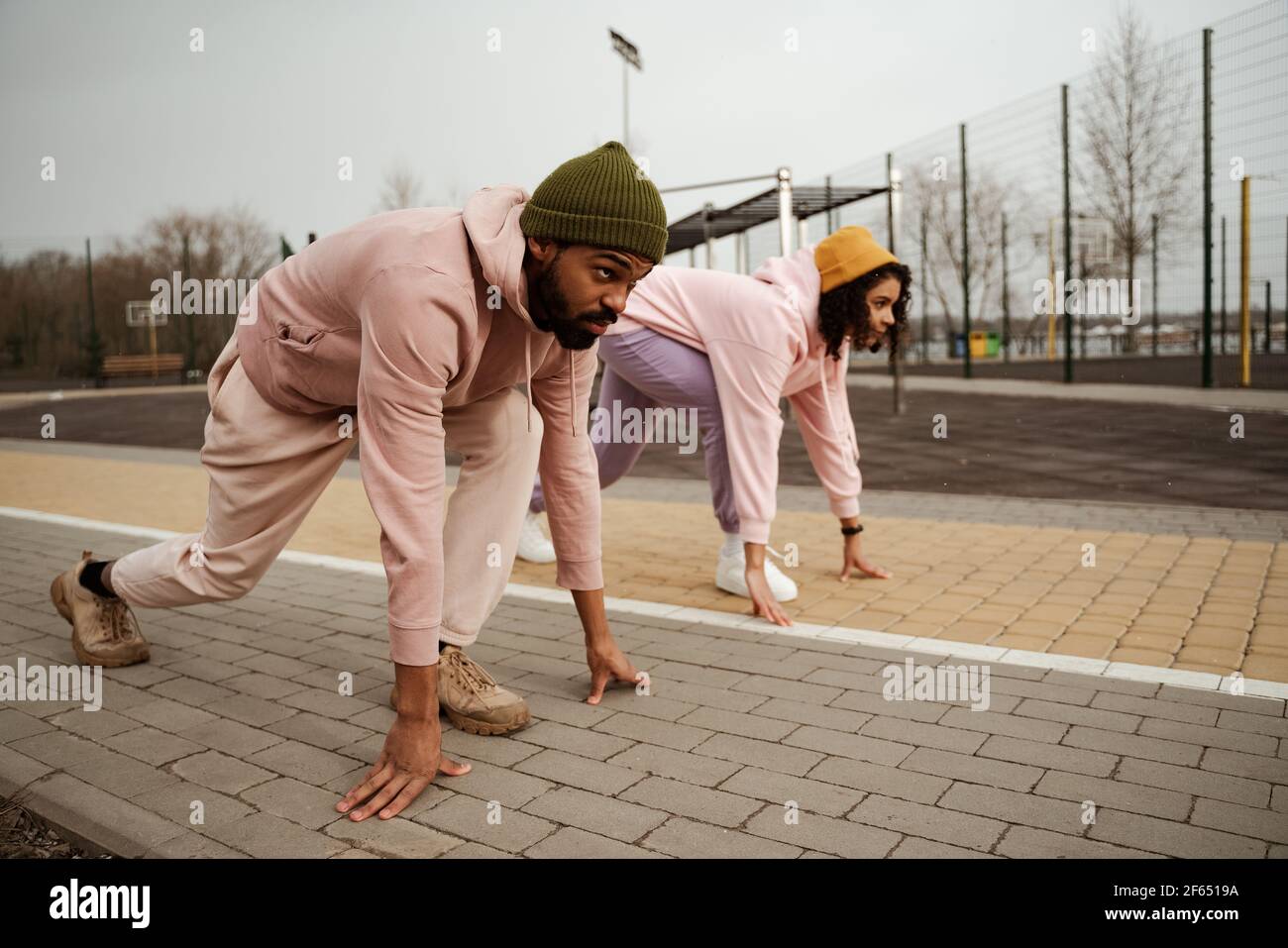 young african american runners standing in low start position on sports ...