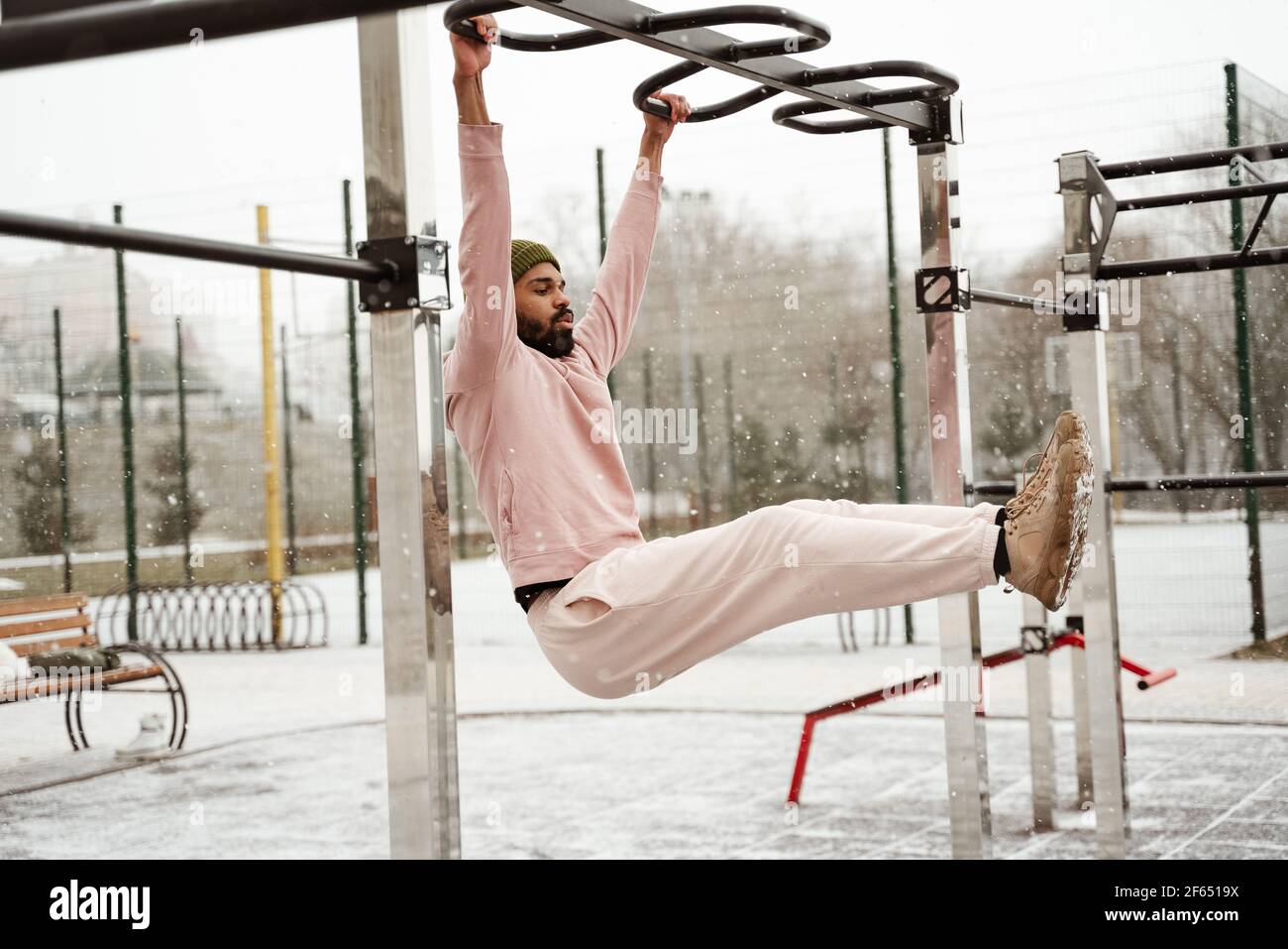 Young man hanging on crossbar hi-res stock photography and images - Alamy