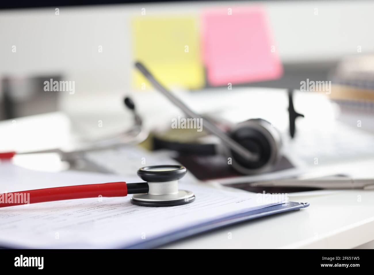 Stethoscope with documents and headphones with microphone on desktop ...