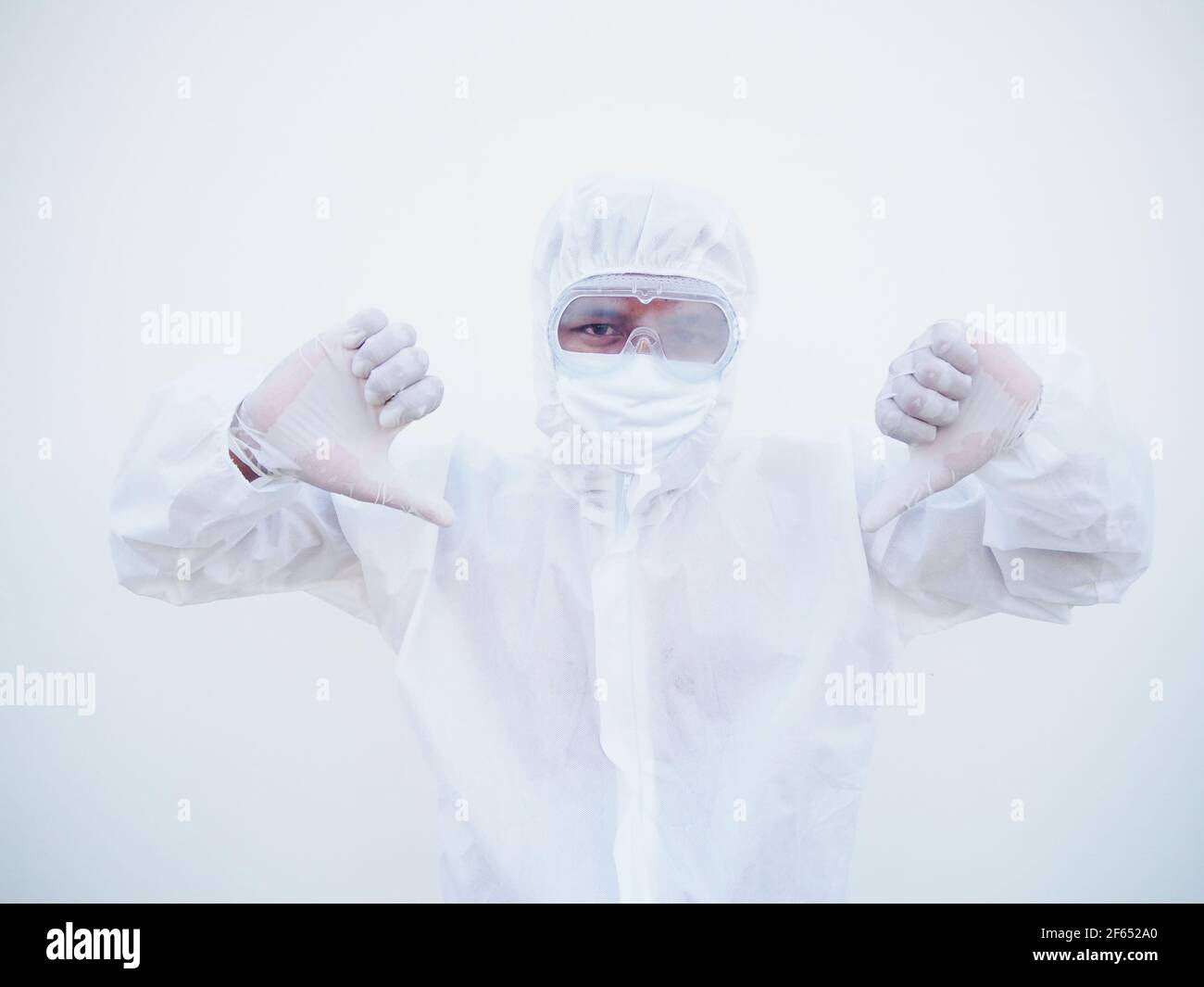 Asian male doctor or scientist in PPE suite uniform showing thumbs down ...