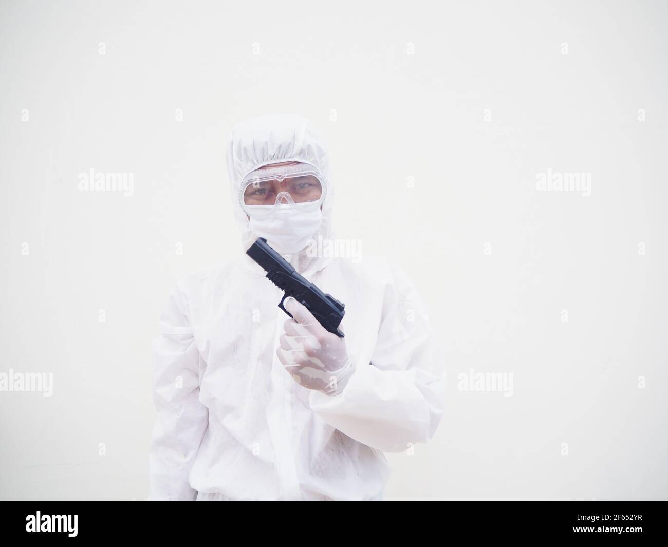 Portrait of doctor or scientist in PPE suite uniform holding gun. COVID ...