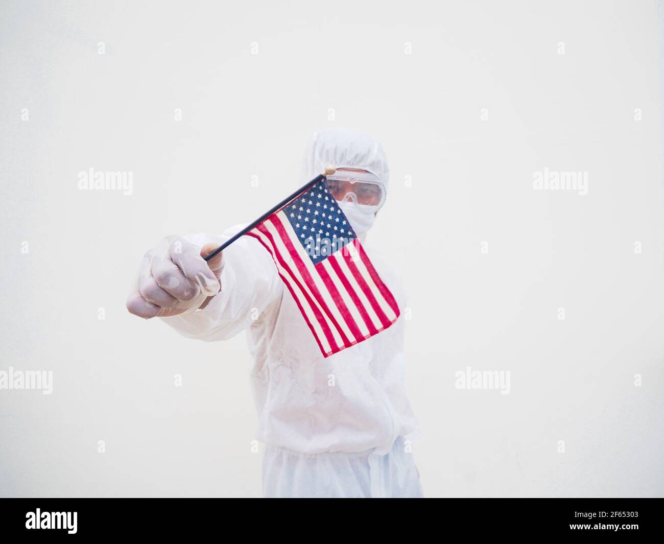 Portrait of doctor or scientist in PPE suite uniform holding national ...