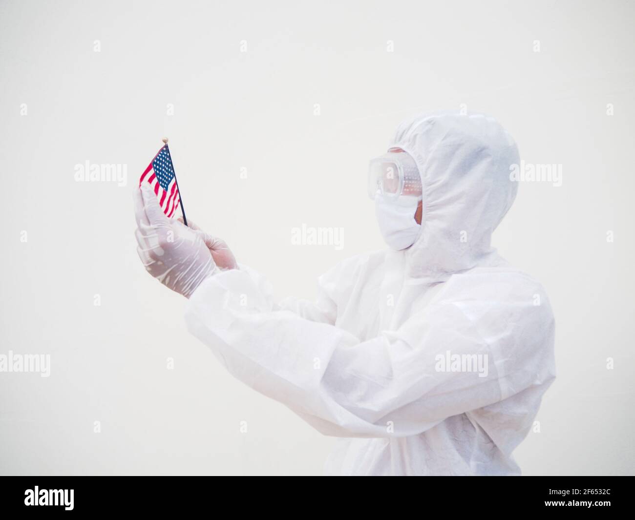 Portrait of doctor or scientist in PPE suite uniform holding national ...