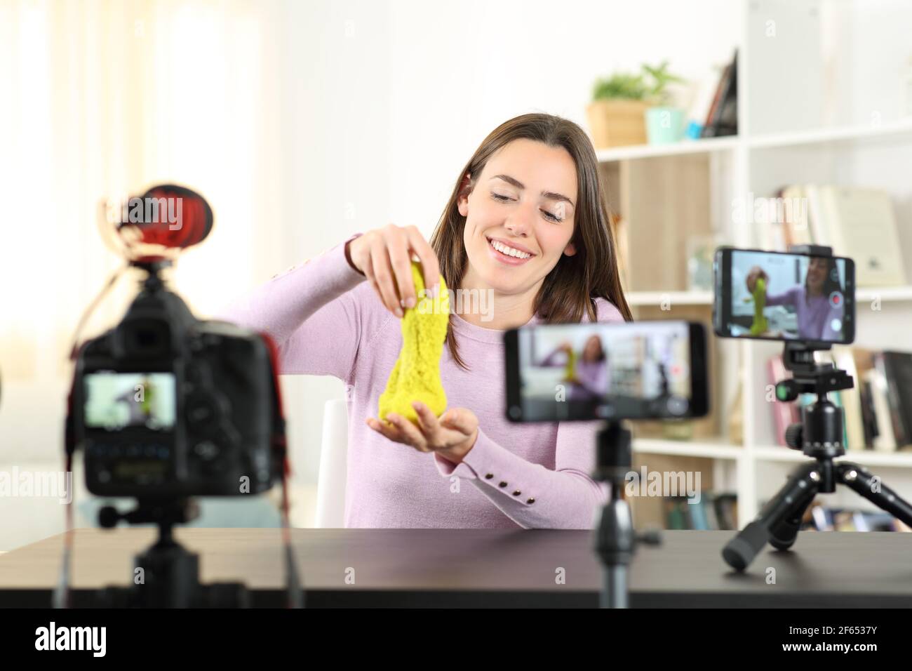Happy influencer recording video playing with cinetic sand using ...