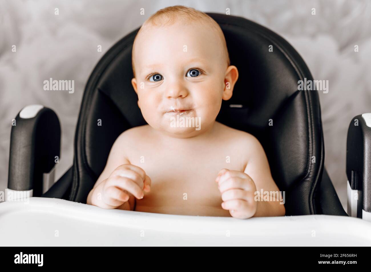 Happy child sitting in a baby chair, baby food concept Stock Photo - Alamy