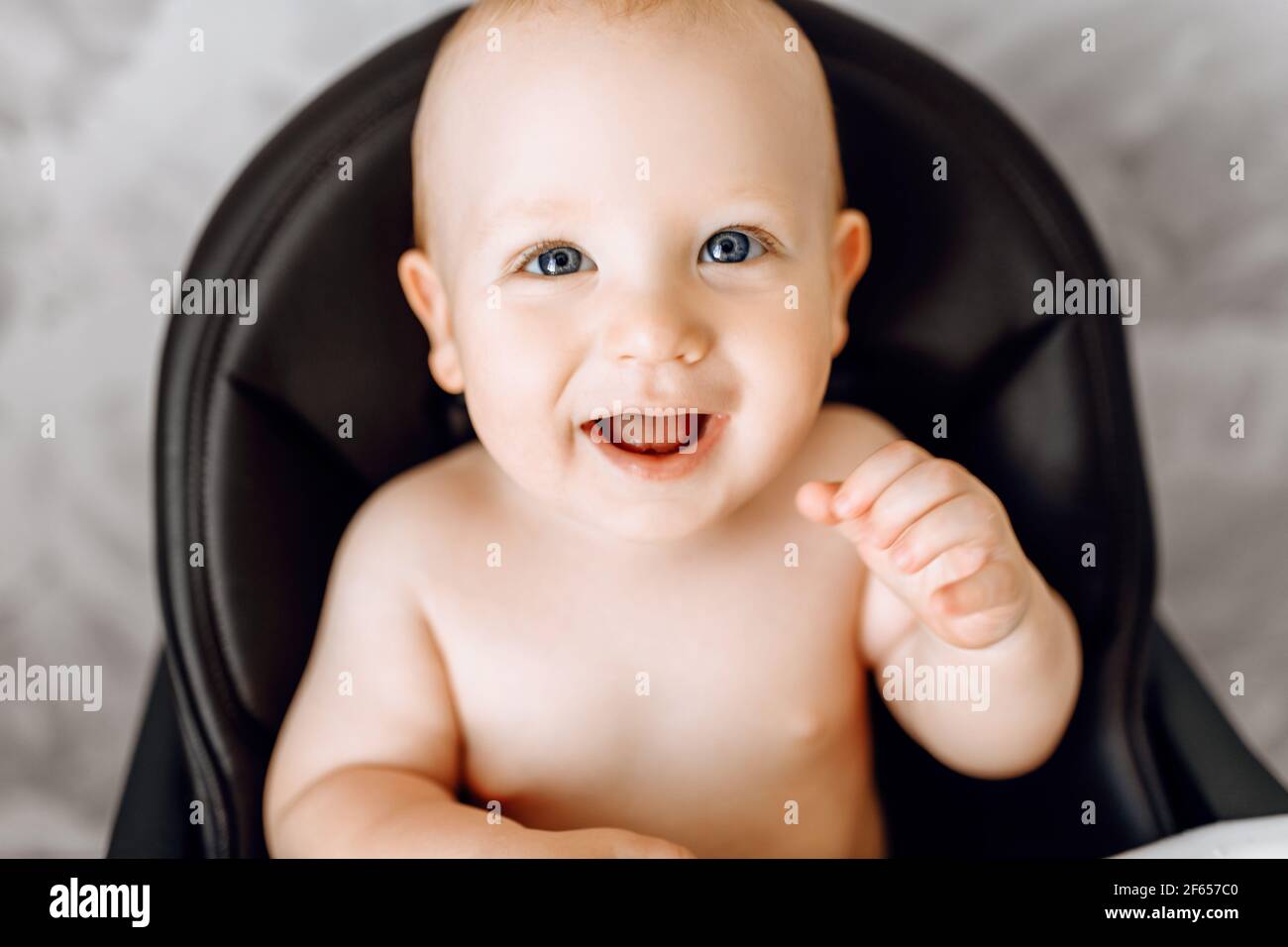 Happy child sitting in a baby chair, baby food concept Stock Photo - Alamy
