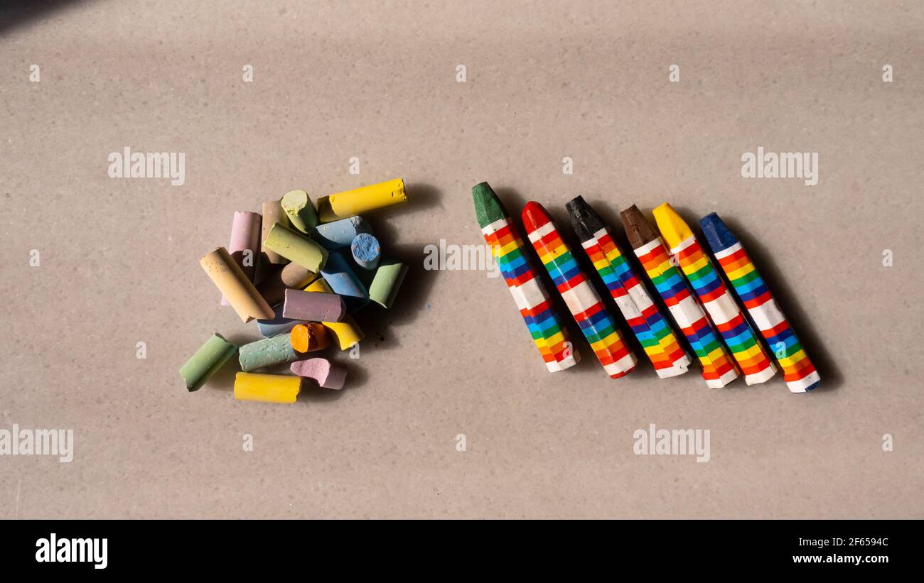 Colorful chalks and crayons on marble countertop, chilhood concept ...