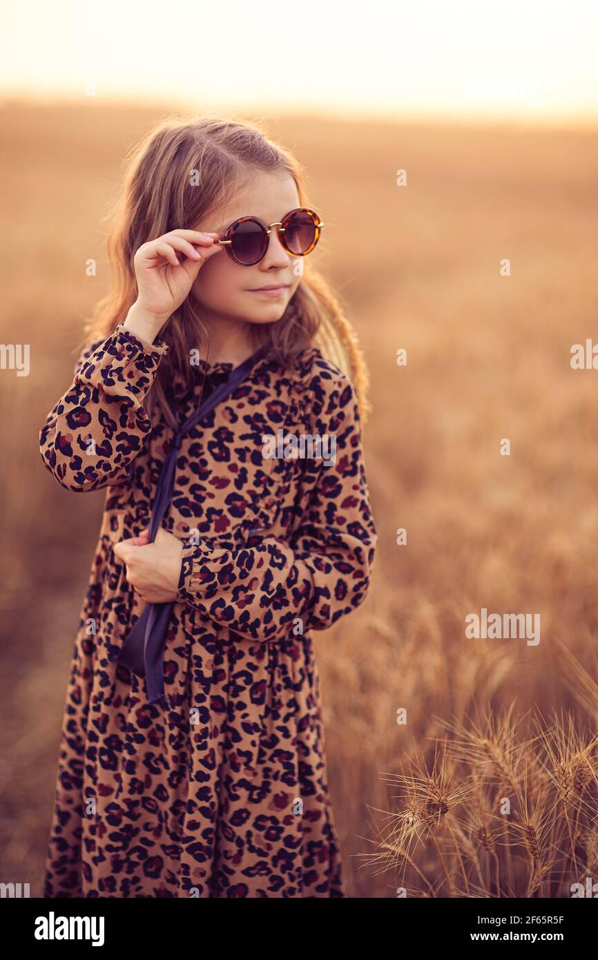 Beautiful little girl wearing leopard dress and rounded sunglasses ...