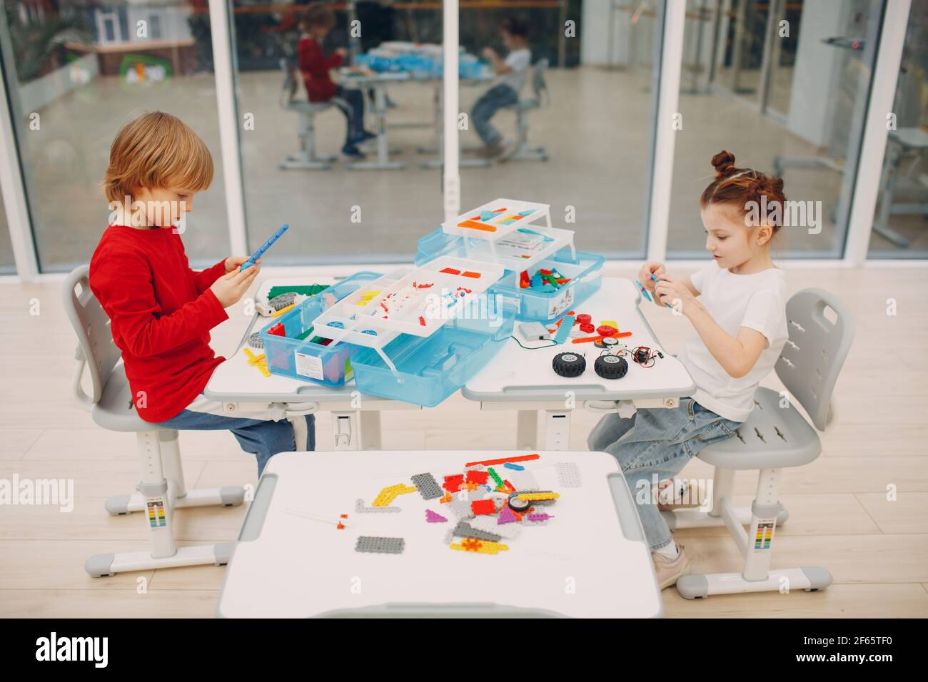 Smiling kids boy and girl child constructor checking technical toy ...