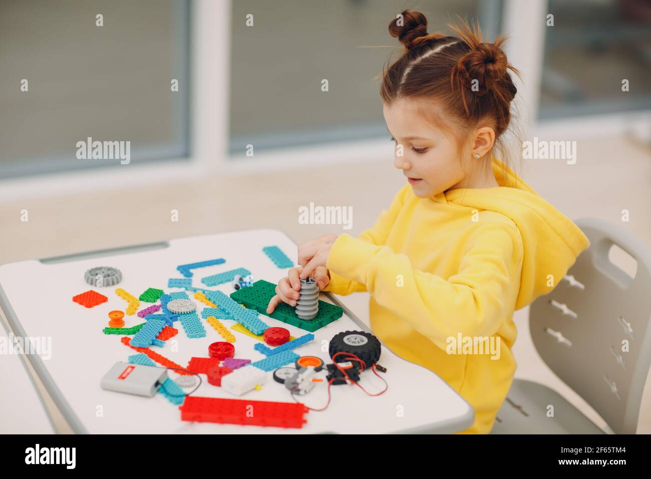 Smiling kid child constructor checking technical toy. Children Robotics ...