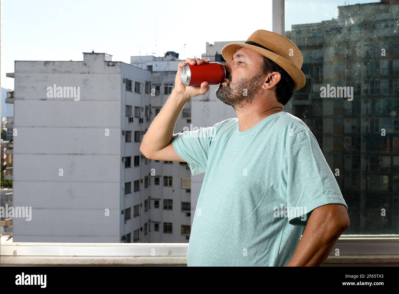 man drinking canned soda at the window during pandemic Stock Photo - Alamy