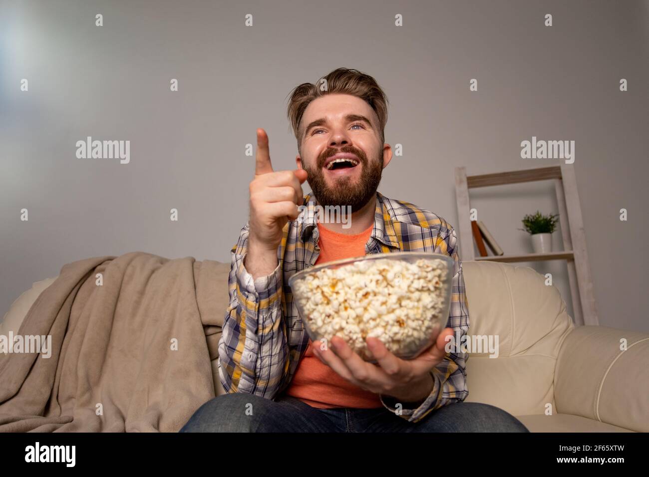 Single man on the couch watching TV Stock Photo - Alamy