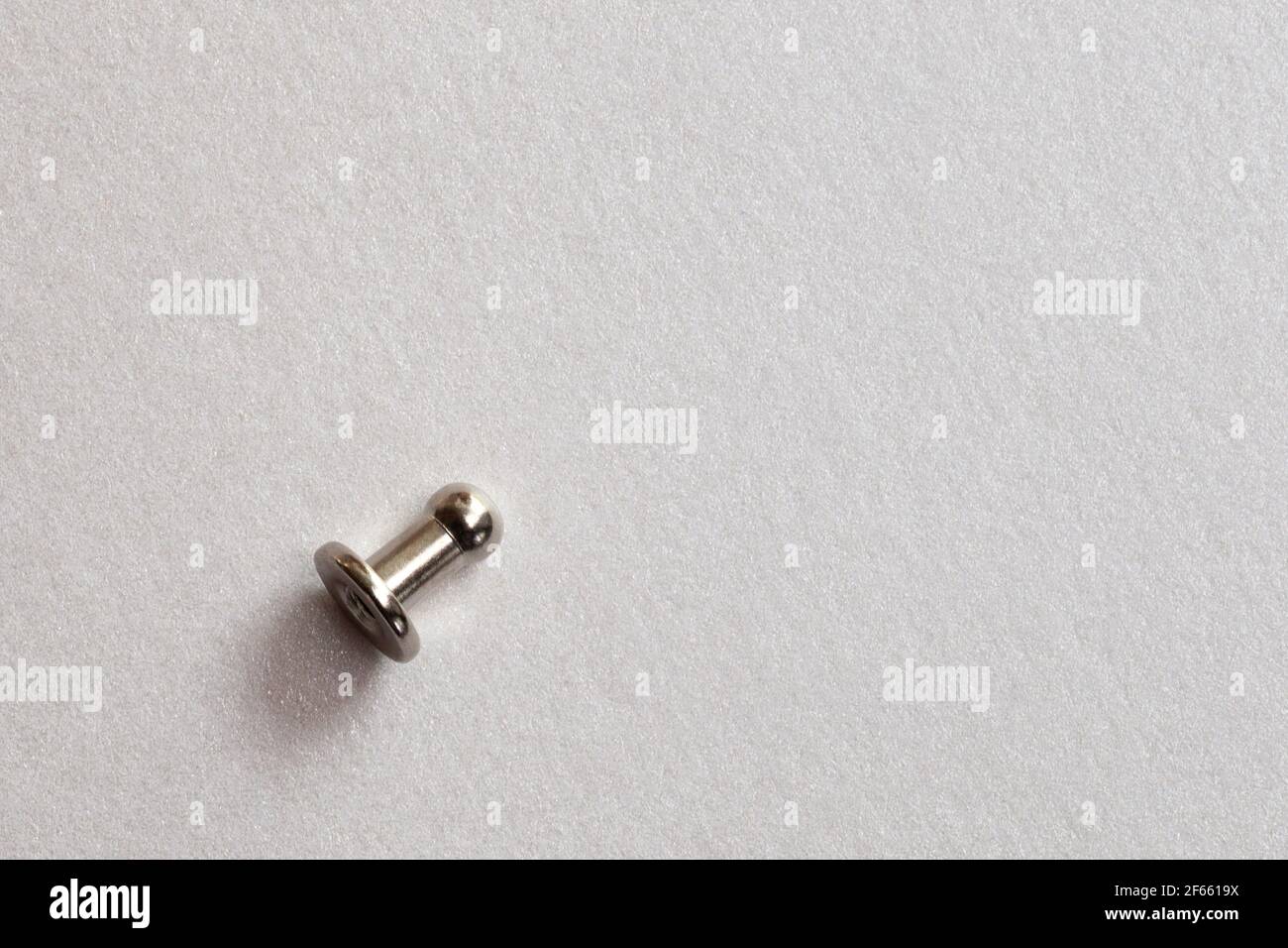 minimalism close-up grommet, rivet, snap, button on the paper silver ...