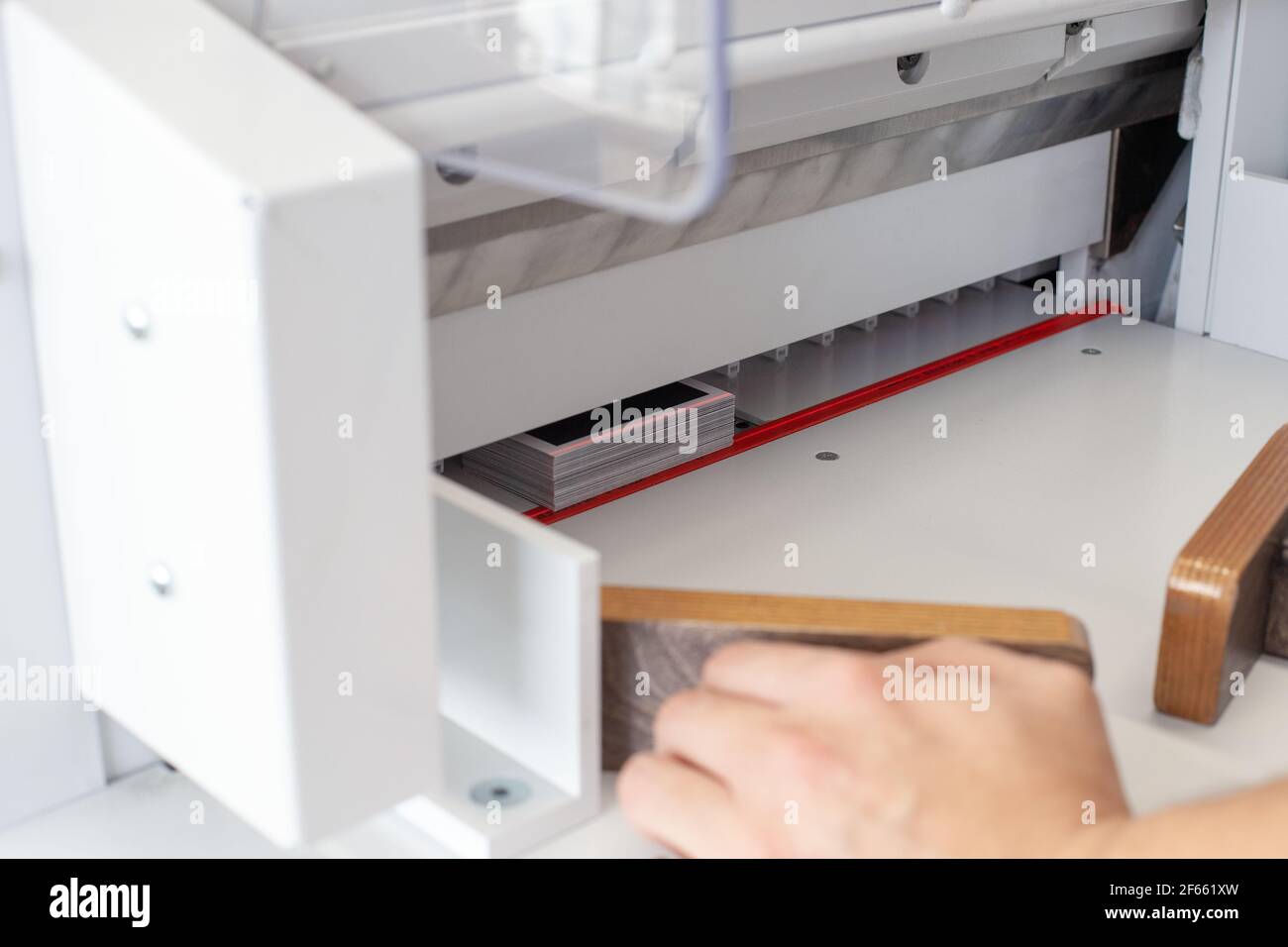 a specialist operator works on an automatic paper cutting machine, a ...