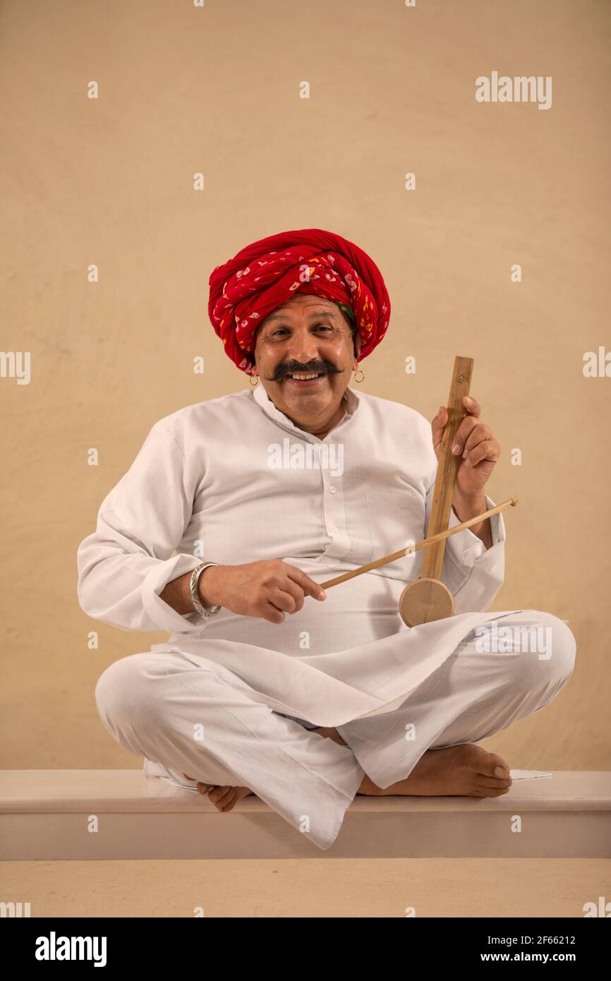 A HAPPY VILLAGER SITTING AND HOLDING EKTARA INSTRUMENT Stock Photo - Alamy